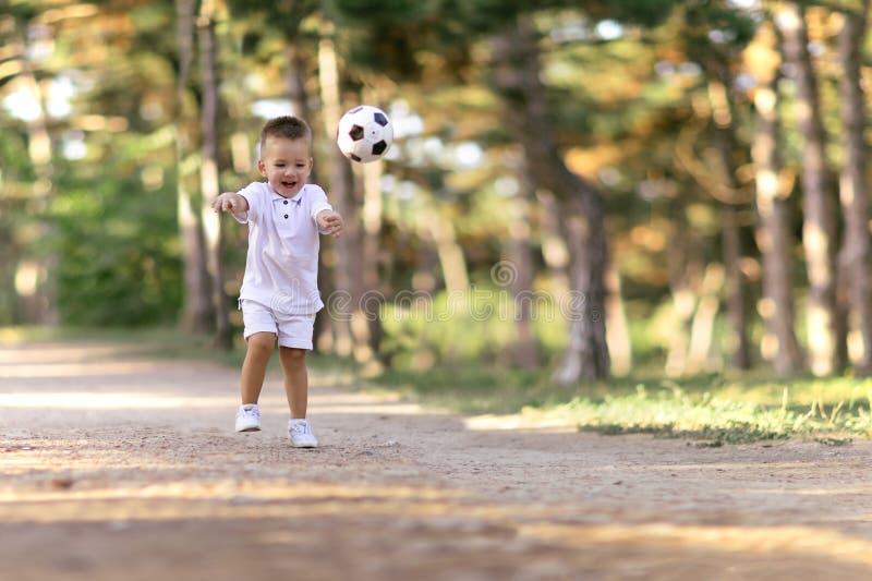 Boy Young Kid Playing with Ball Kicks Running Towards Ball in Park ...