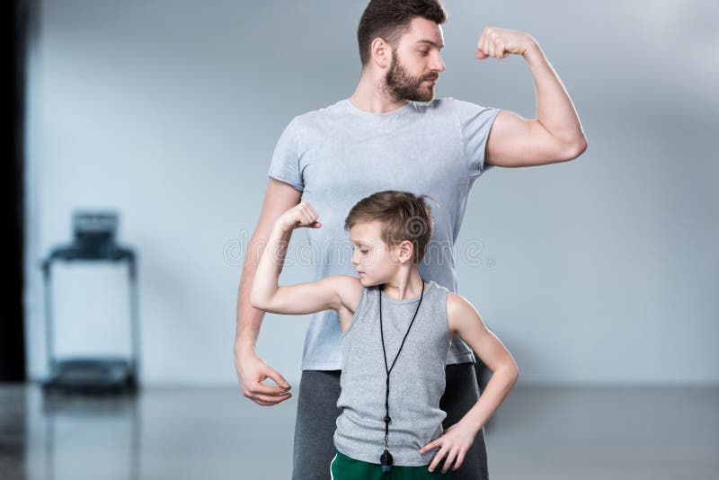 Boy with Young Man, His Trainer or Father Showing Muscles Stock Photo ...