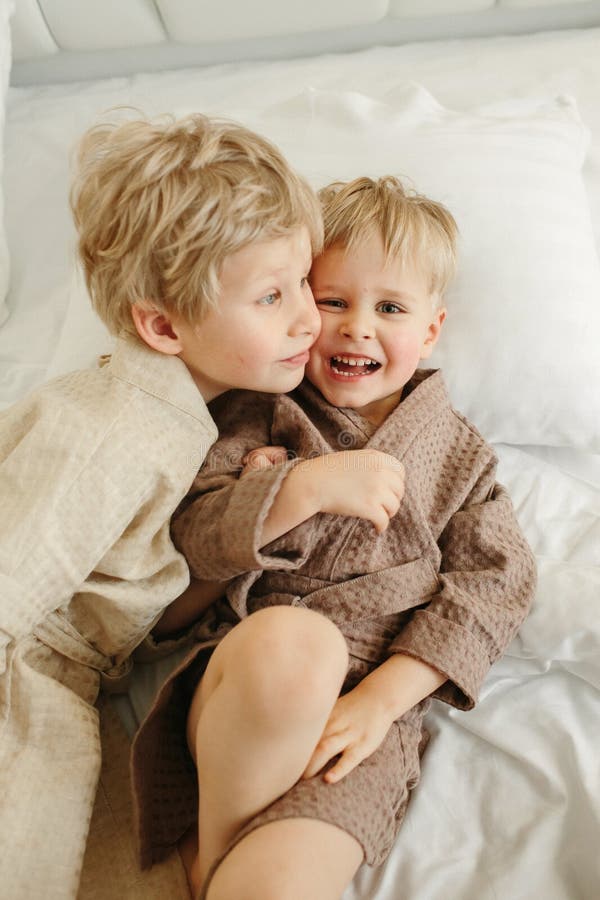 Boys, Brothers Lie on the Bed in Dressing Gowns, Play Stock Photo ...