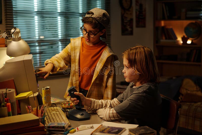 Boys Collaborating on Old Computer in Dimly Lit Room Stock Photo ...