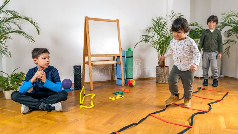 Boys Jumping Over Ladders stock photo. Image of child - 211216788
