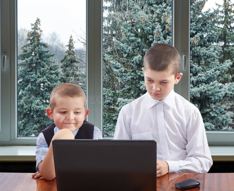 Boys Look at the Laptop Against the Window with Christmas Trees Stock ...