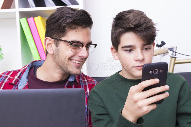 Boys Looking at Screen of Mobile Phone Stock Photo - Image of jumper ...