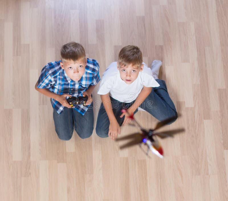 Boys Playing with Flying Helicopter Model at Home Using Remote Control ...