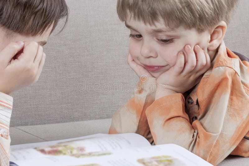 The Boys Read a Book and Look at Various Pictures in it Stock Photo ...