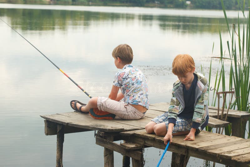Boys Sitting and Fishing from a Dock Stock Photo - Image of natural ...