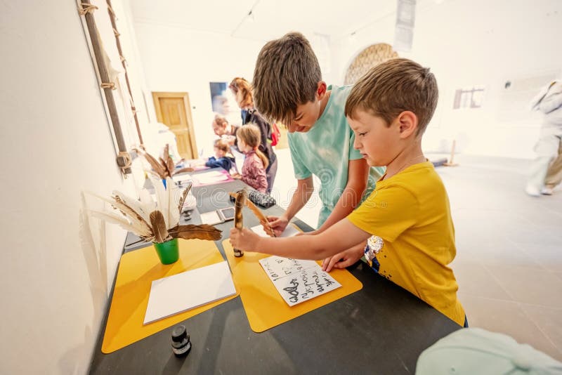 Boys Writing with Feather Quill Pen at Desk Stock Image - Image of ...