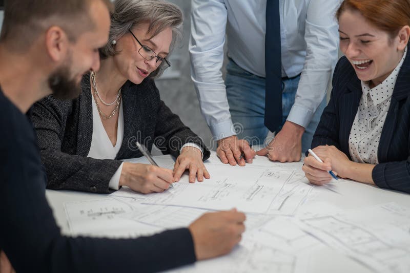 Brainstorming of Four Engineers and Architects with Blueprints in the ...