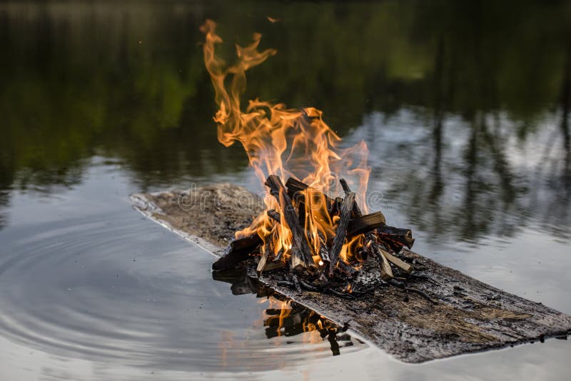 A Raft with a Bright Burning Fire, Floats in the Middle of a River, in ...