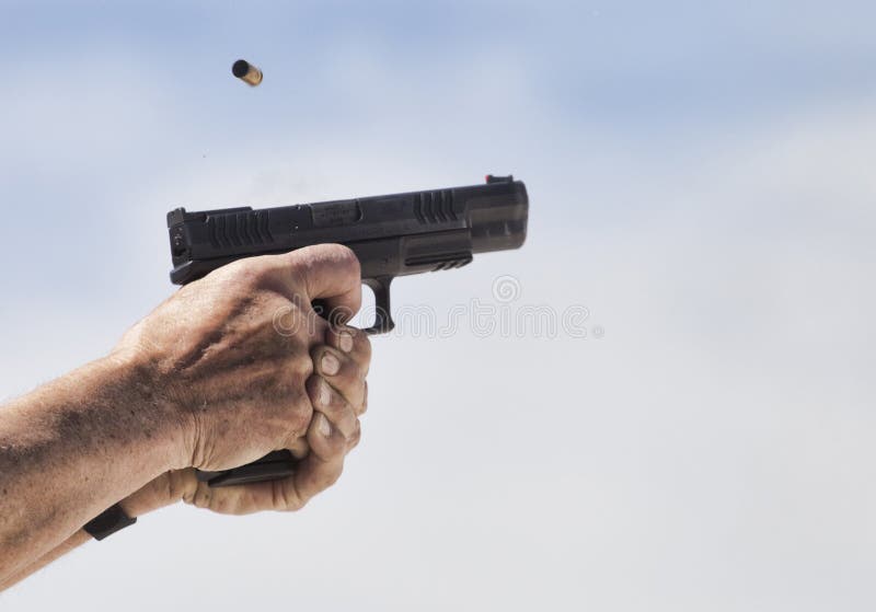 Brass Flying from a Handgun with Sky Behind Stock Photo - Image of ...