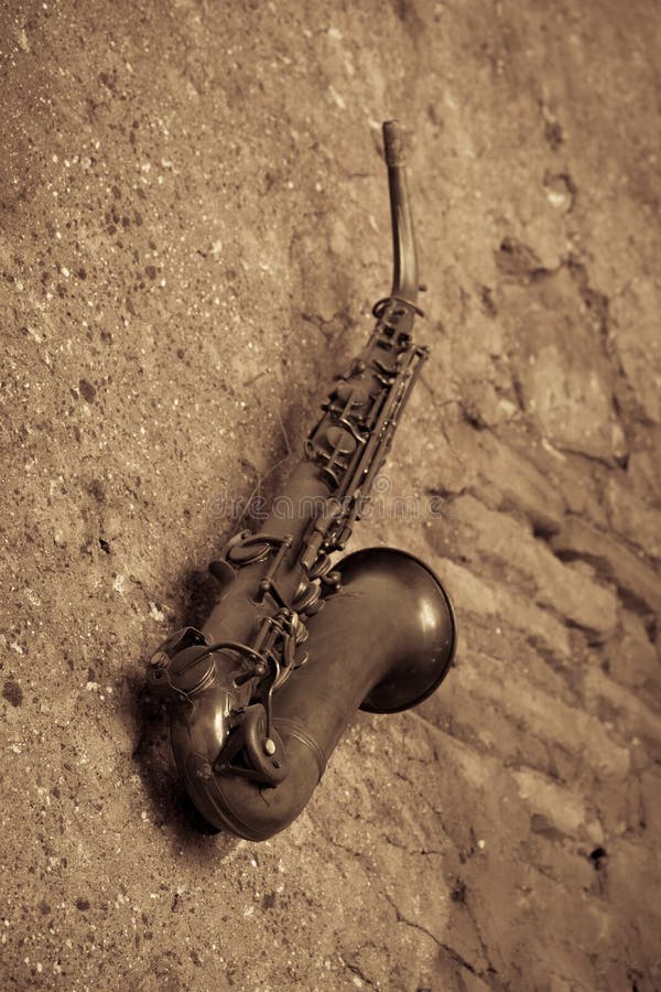 Brass Saxophone Hanging on a Stone Wall Stock Image - Image of ...
