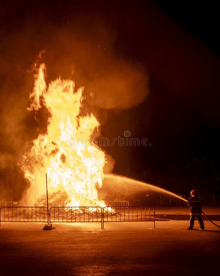 Brave Firefighter Extinguishing a Large Raging Bonfire at Night Stock ...