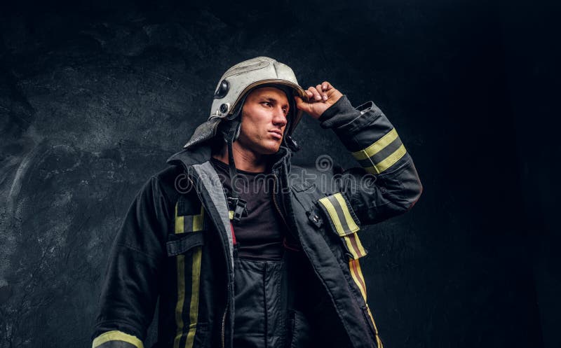 Brave Fireman in a Fire Suit Looking Sideways and Correcting the Helmet ...