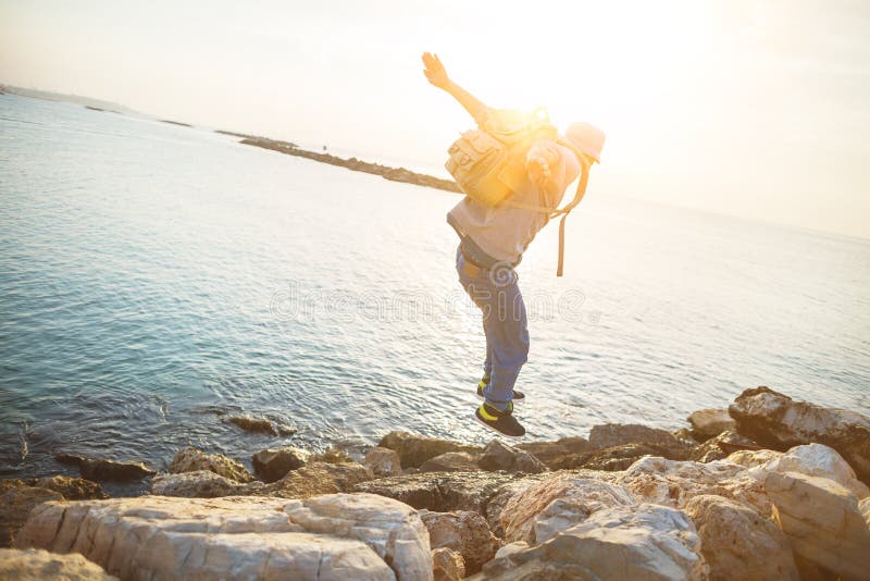 Brave Man with Backpack Jumping Over Rocks Stock Image - Image of ...