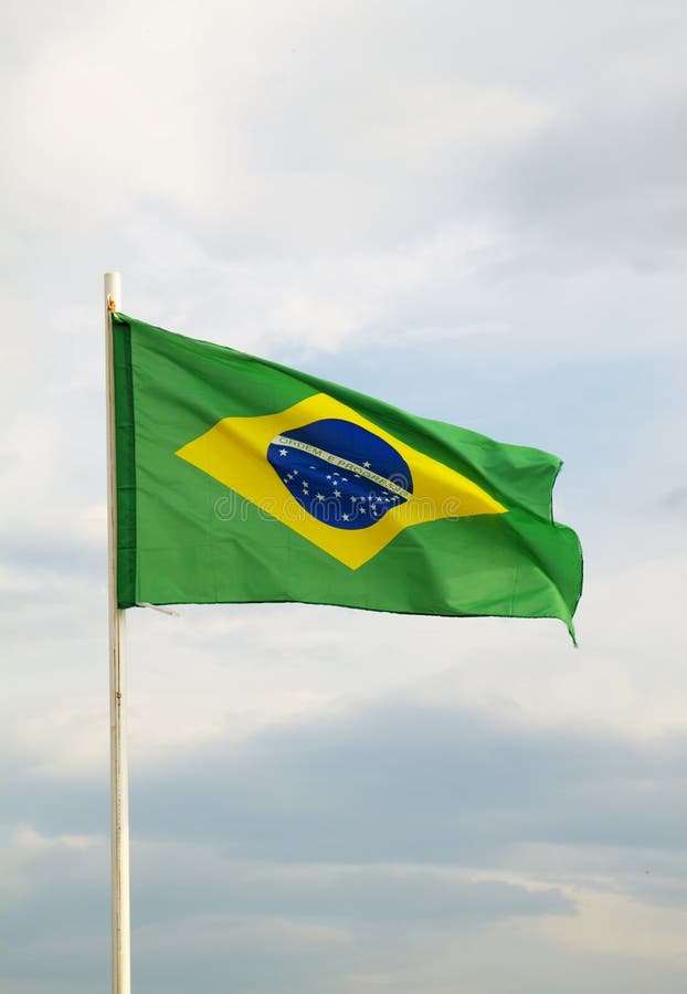 Brazilian Flag on a Blue Sky with Clouds Background Stock Photo - Image ...
