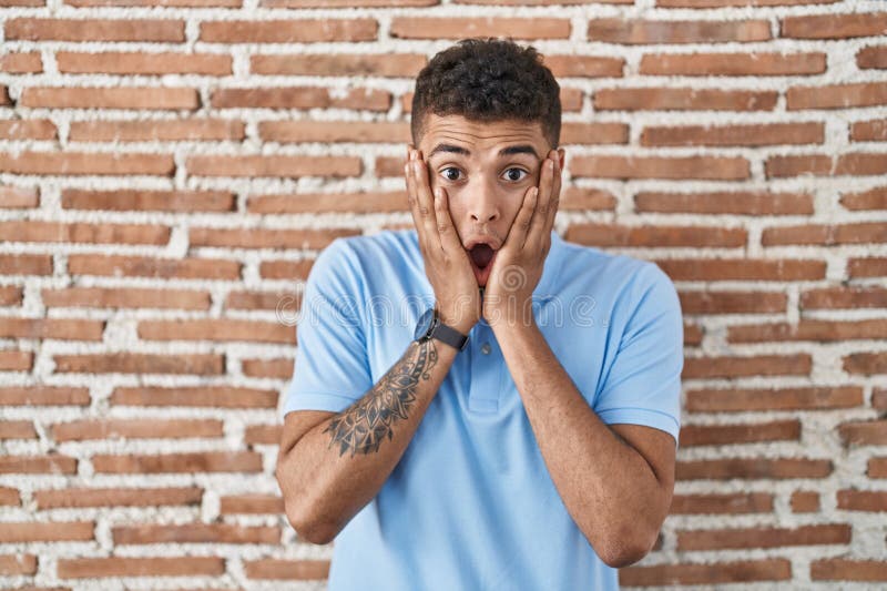 Brazilian Young Man Standing Over Brick Wall Afraid and Shocked ...