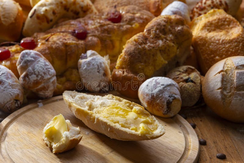 Bread with Melted Butter and Various Artisan Breads on a Wooden Table ...