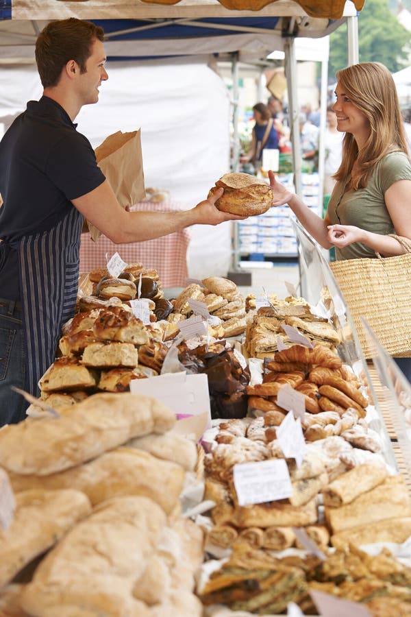 Bread Stall Owner at Market Serving Customer with Loaf Stock Image ...