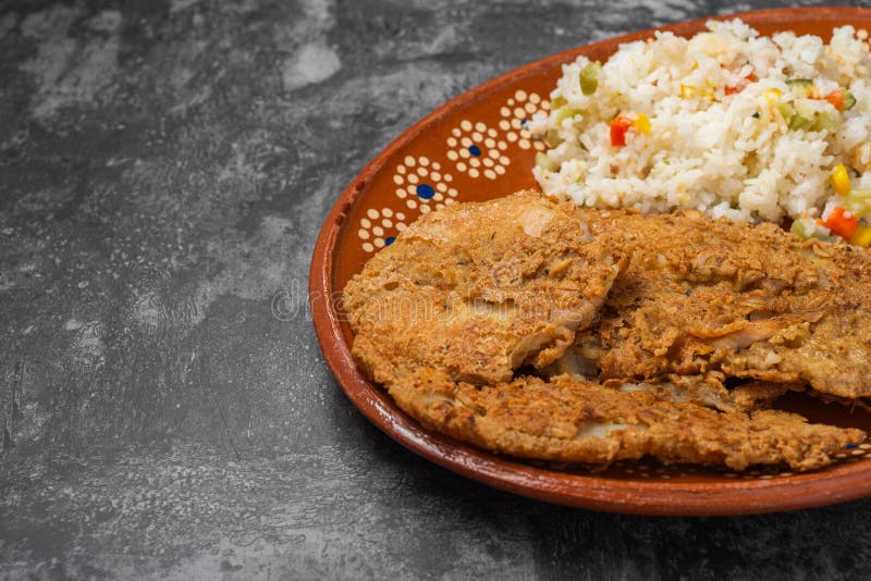 Breaded Fried Fish and Rice in a Clay Dish Stock Photo - Image of ...