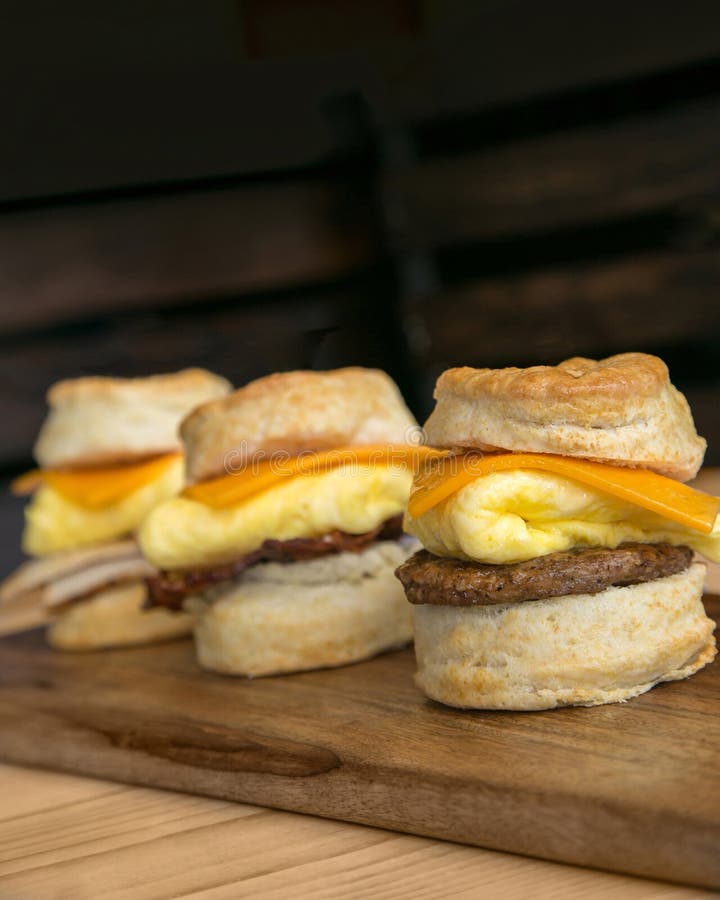 Breakfast Biscuits with Egg, Sausage, and Cheese on Wood Serving Board ...