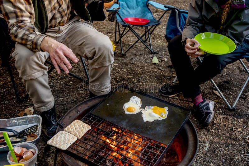 Breakfast Camp Cooking. Man Cooking Grilling Eggs and Warming Bread on ...