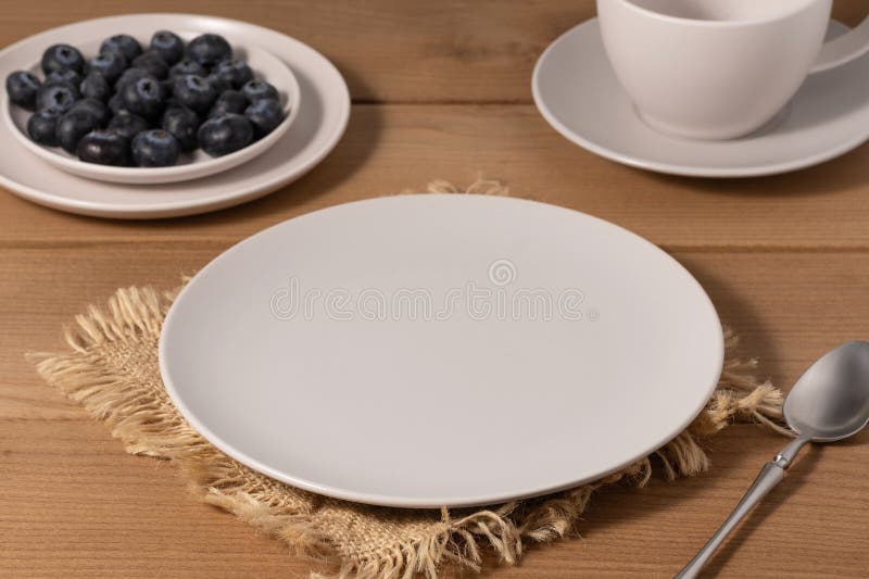 Breakfast Setting on a Wooden Table with Empty Plate, Blueberries, and ...