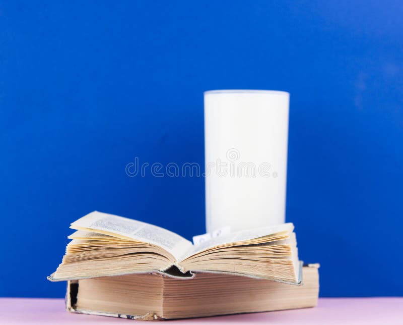 Breakfast. Stack of Books and a Glass of Milk Over Blue Wall Stock ...