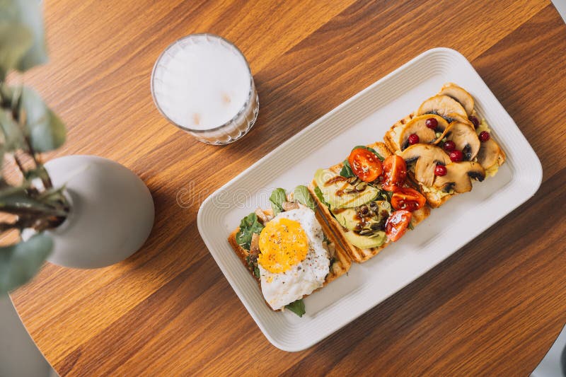 Breakfast Toasts with Different Toppings on a Plate with a Cup of ...