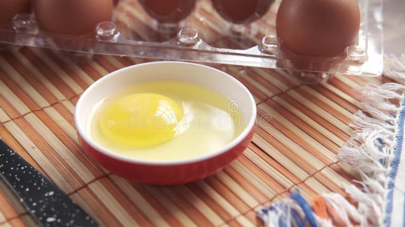 Breaking Egg and Pouring into a Small Container on Table , Stock ...