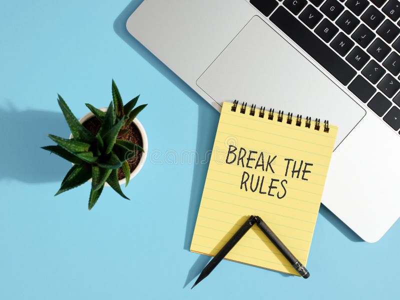 Breaking the Rules: Notepad with a Pen, Laptop, and Plant on a Blue ...