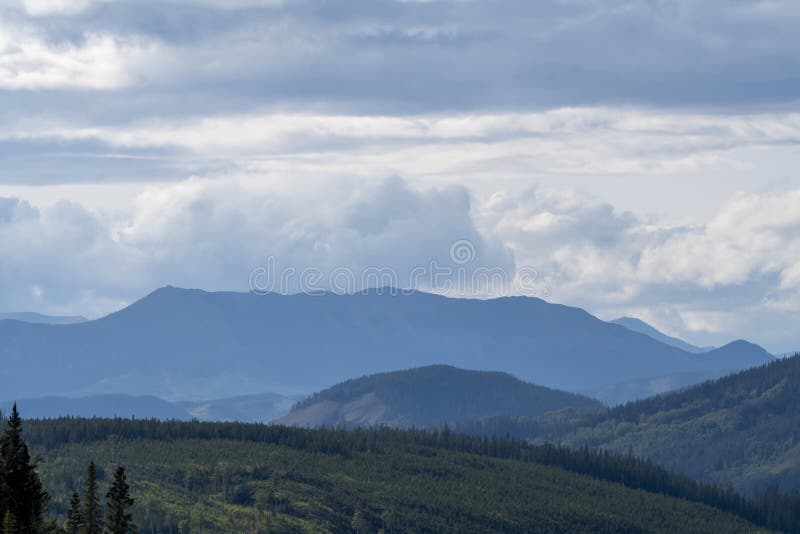 Breathtaking Mountain Range Covered by Forest Under Cloudy Sky Stock ...