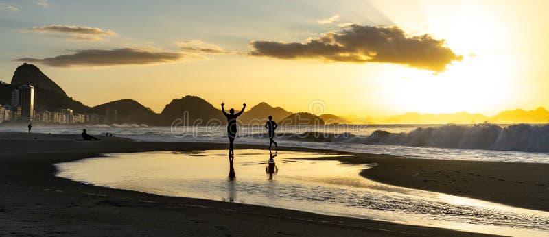 Breathtaking Scene of Two Human Silhouettes Running Along the Beach ...