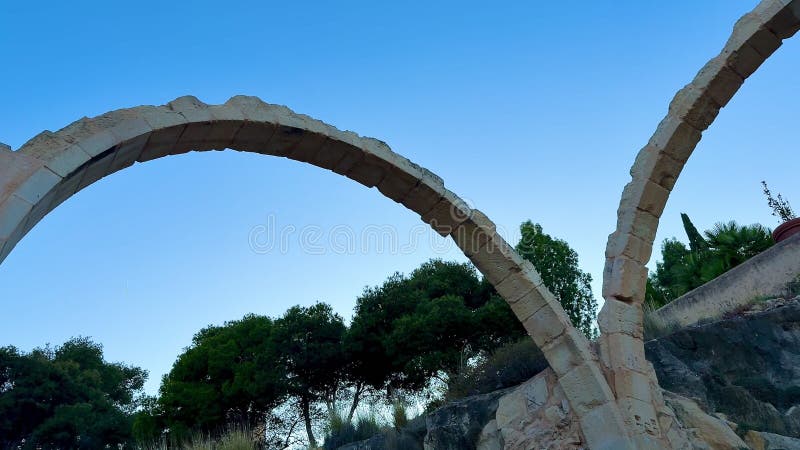 Rustic Stone Arches Beautifully Against a Clear Blue Sky, Evoking a ...