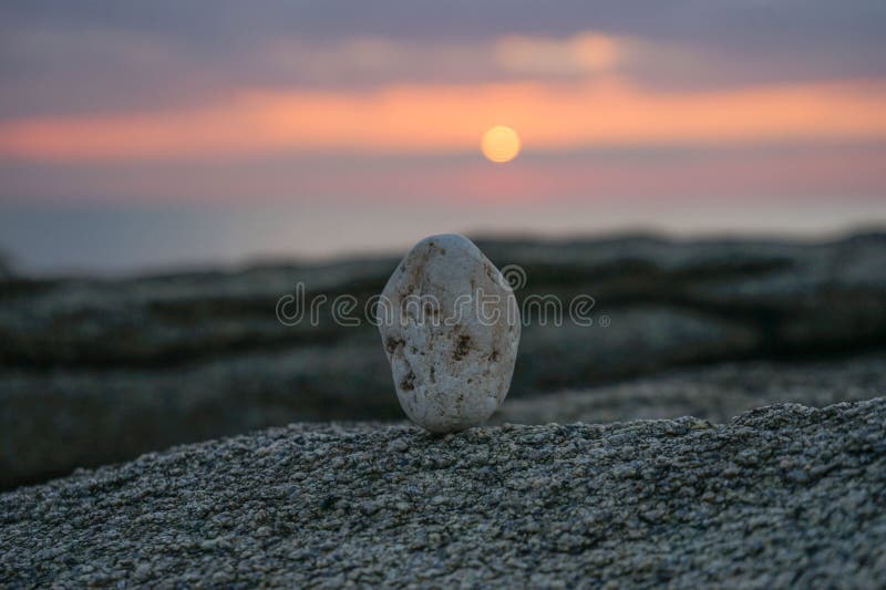 Breathtaking Shot of a Sunset Behind a Round Natural Rock on the Shore ...