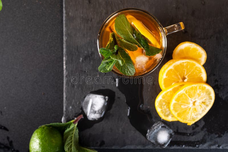 Brewed Tea with Mint and Lemon. Pieces of Melting Ice and Tea. Close-up ...