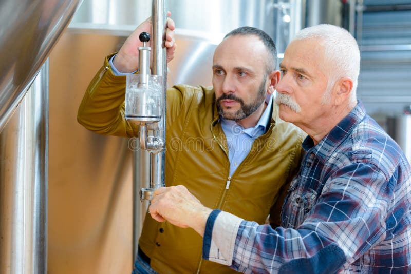 Brewery Workers Pouring Beer into Glass Stock Photo - Image of foam ...