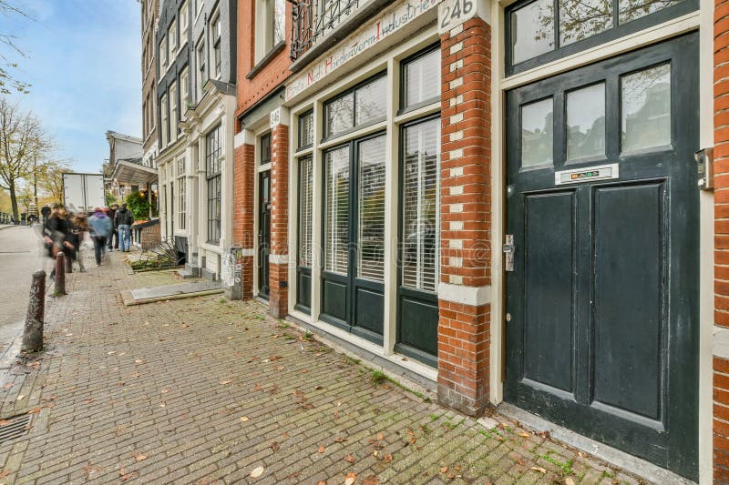 A Brick Building with Black Doors on a Street Editorial Stock Image ...