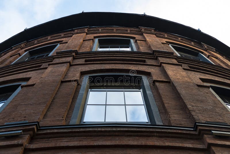 Brick Building with the Bottom, the Sky is Reflected in the Windows ...