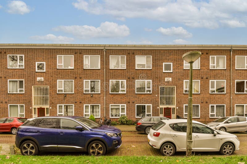 A Brick Building with Cars Parked in Front of it Stock Photo - Image of ...