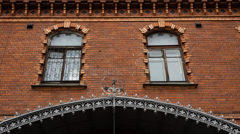 A Brick Building with Elegant Arched Windows and a Wrought Iron Arch ...