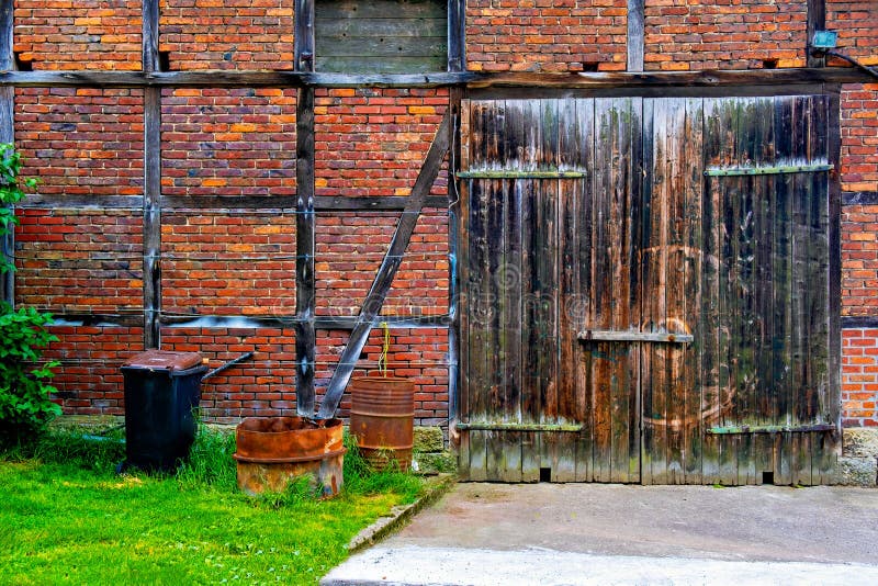 Brick Building with Wooden Door and Trash Can in Front of it in Germany ...