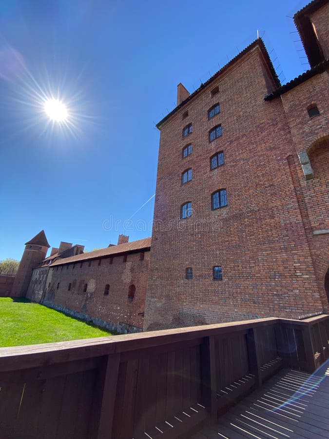 Brick Castle Wall Bathed in Sunlight Under a Clear Blue Sky, Reflecting ...