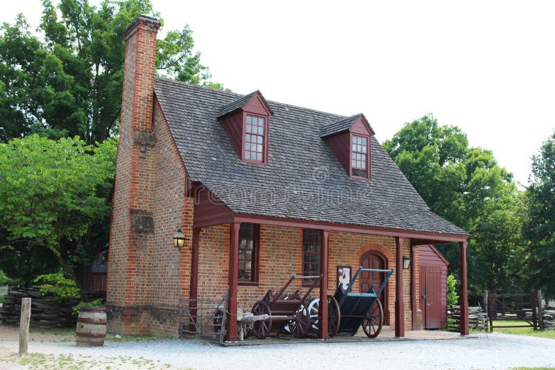 A Brick Farmhouse with an Open Storage Shed and Farming Tools Stock ...