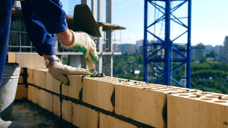 A Brick is Getting Inserted and Leveled in the Building Wall Stock ...