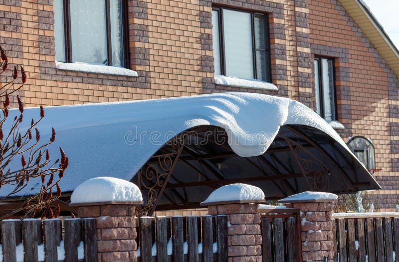 A House with a Snow Covered Roof and Awning Stock Photo - Image of ...