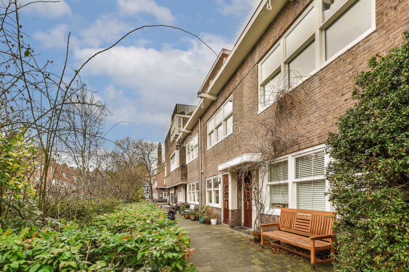 A Brick House with a Bench in Front of it Stock Image - Image of trees ...