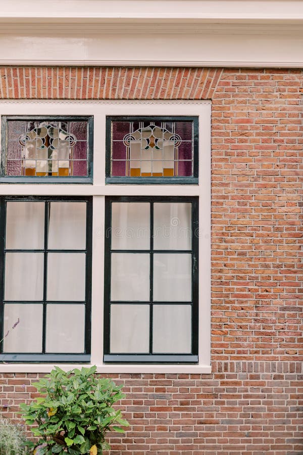 A Brick House Facade with Two Large Windows. Stock Image - Image of ...