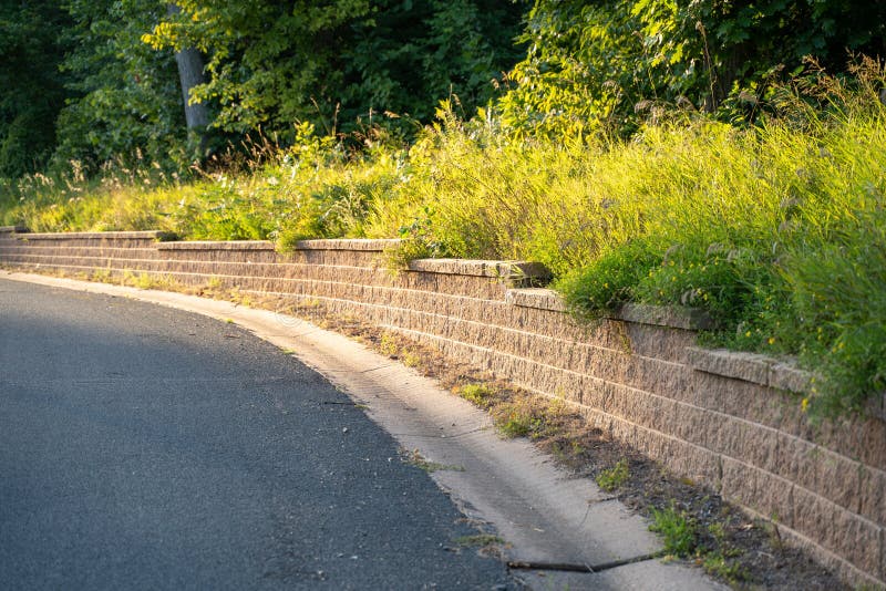 Brick Retaining Wall on a Curve of a Paved Road Stock Photo - Image of ...