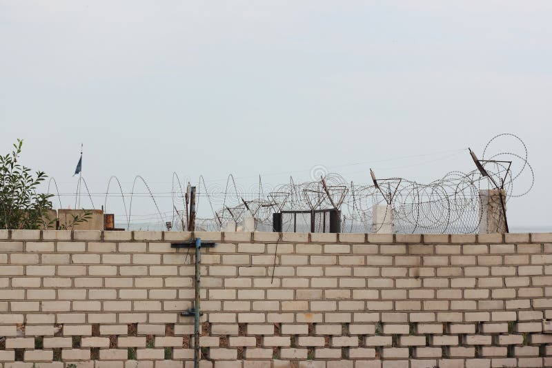 Brick Wall Behind Barbed Wire Stock Photo - Image of wire, zone: 76658338