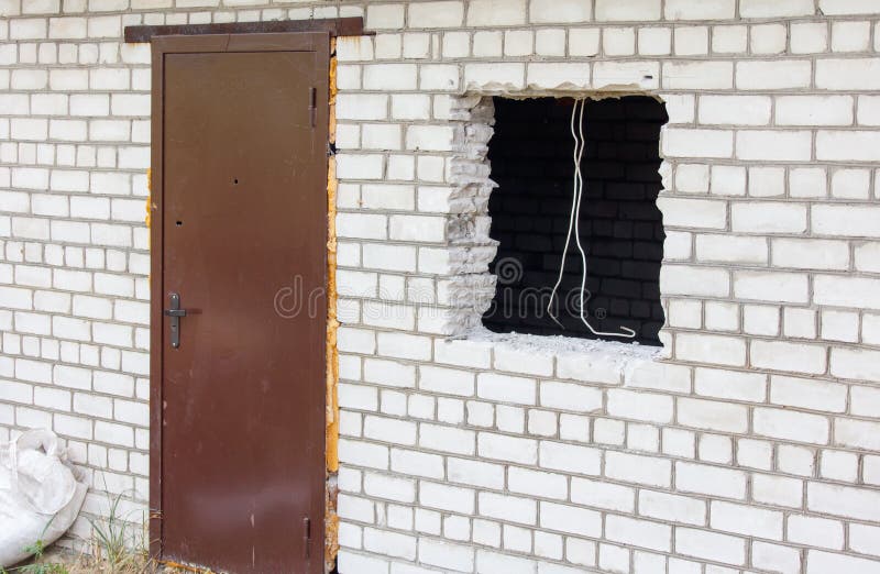Brick Wall with a Closed Door and a Partially Constructed Window with ...